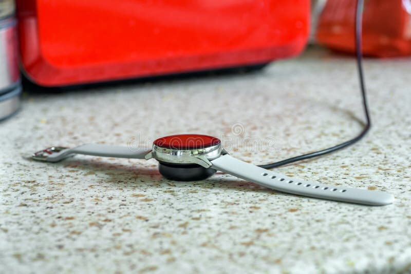 Smart Watch Wireless Charging on Charging Pad on Kitchen Worktop Table ...