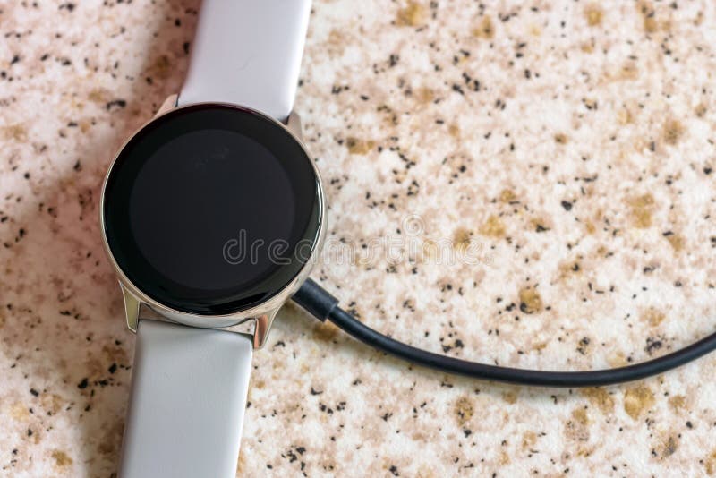 Smart Watch Wireless Charging on Charging Pad on Kitchen Worktop Table ...