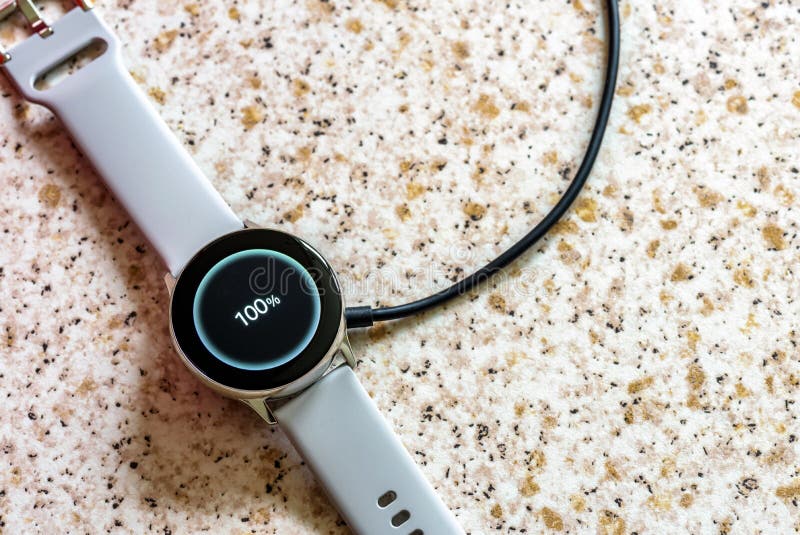 Smart Watch Wireless Charging on Charging Pad on Kitchen Worktop Table ...