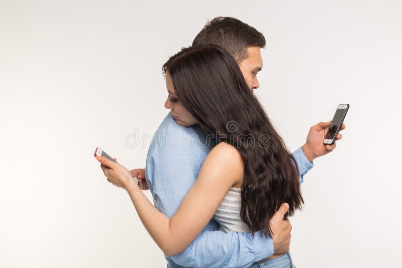 Smartphone Addiction Concept - Young Couple Hugging and Typing on Their ...