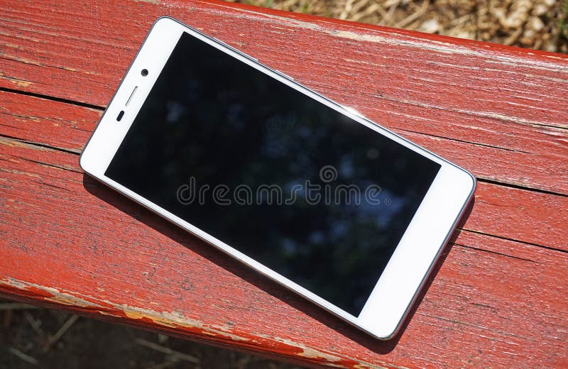 Smartphone on a bench stock image. Image of device, digital - 98490515