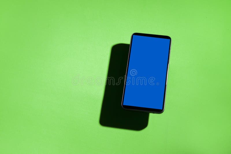 Smartphone with a Blue Screen on Top of a Green Table. Stock Photo ...