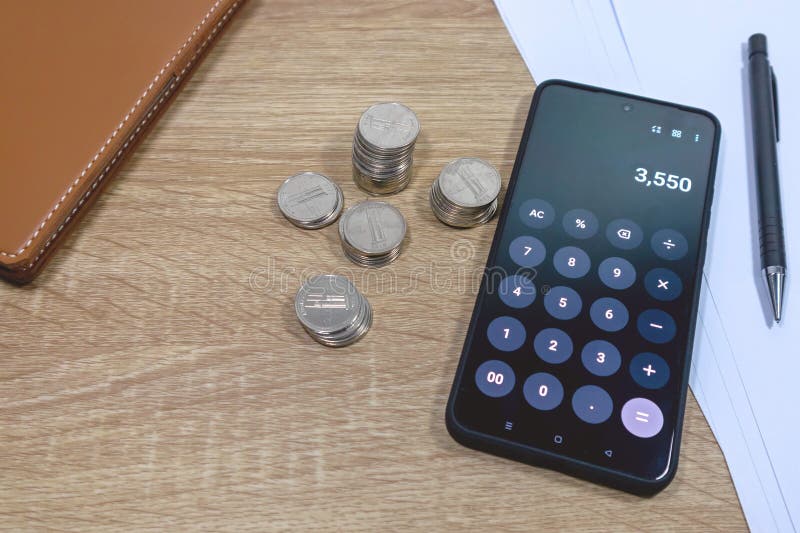 A Smartphone with Calculator Apps on the Screen with Coins, Paper, Pen ... A Smartphone with Calculator Apps on the Screen with Coins, Paper, Pen ...