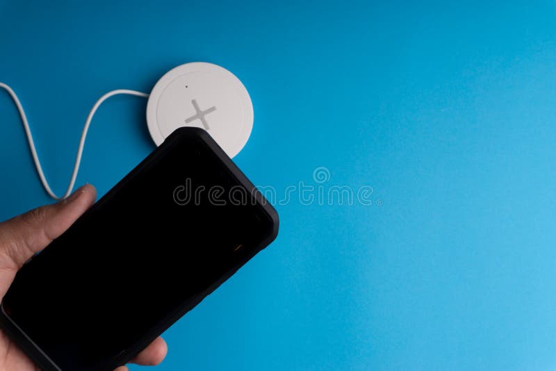 Smartphone Charging on a Charging Pad or Dock on Blue Background ...