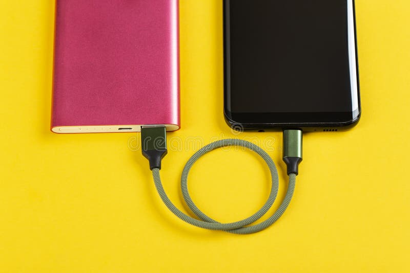 Smartphone Charging with Pink Power Bank on Yellow Background Stock ...