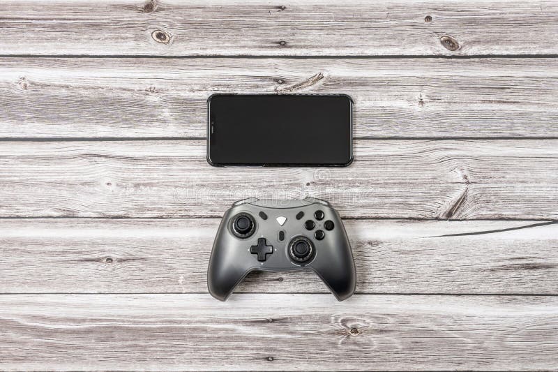 A Smartphone and a Gamepad on a Light Wooden Table Stock Image - Image ...