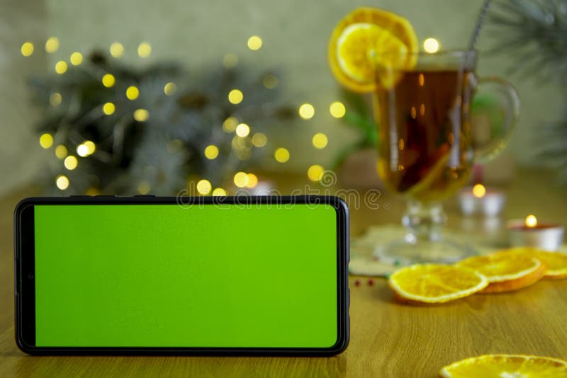 Smartphone with Green Screen Against Blurry Specks of Garland and ...