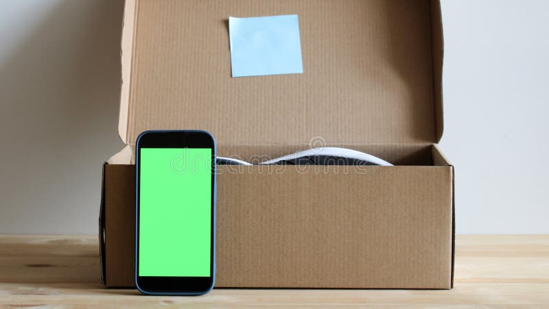 Smartphone with Green Screen Leaning on Cardboard Box with Sneakers ...