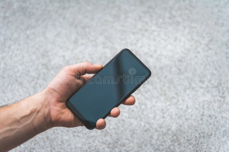 Smartphone in Hand, on the Background of Concrete Tiles. Stock Image ...