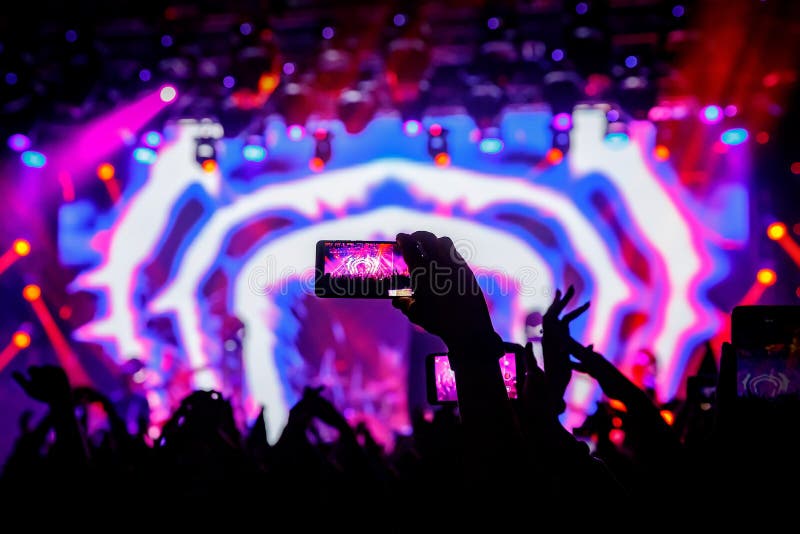 Smartphone in Hand at a Concert, Purple Light from Stage Stock Image ...