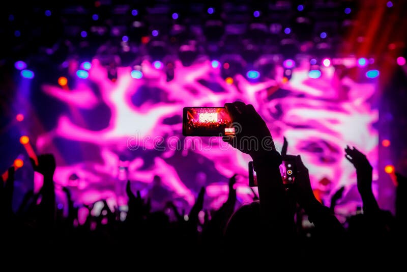 Smartphone in Hand at a Concert, Purple Light from Stage Stock Photo ...