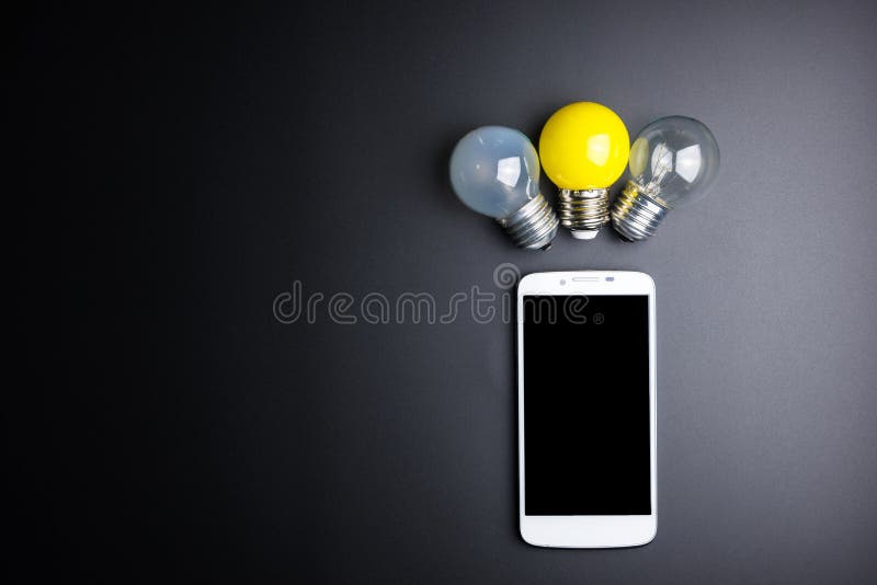 Smartphone and Light Bulb on Black Background with Copy Space. Stock ...