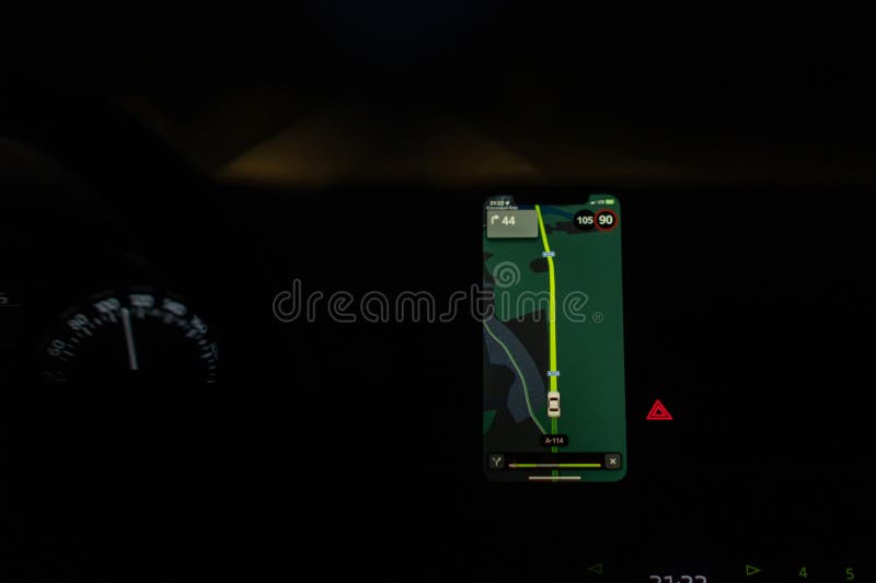 A Smartphone Mounted in a Car Shows a Navigation App with Directions on ...