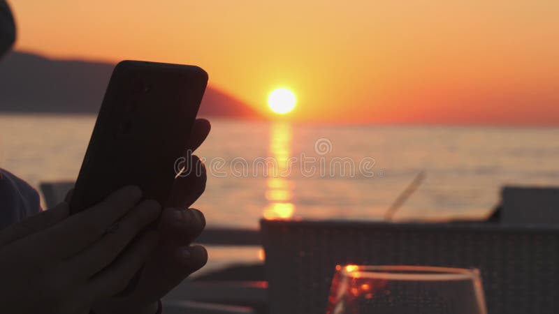 On Smartphone at a Resaturant with Seaside Sunset, Digital Distraction ...