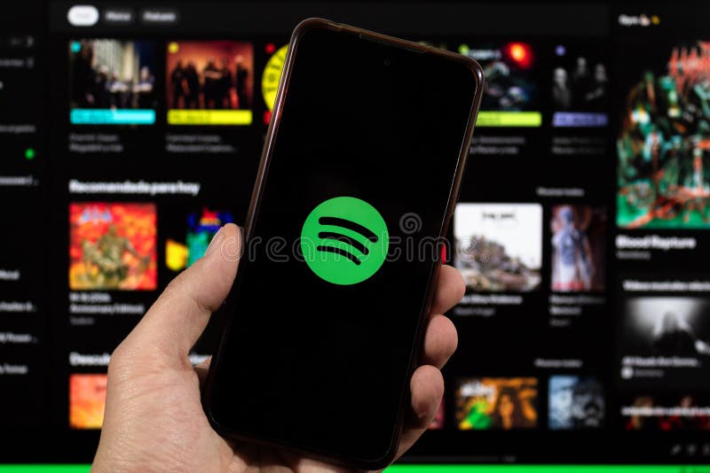 A Smartphone with Spotify App Symbol Over Blurred Spotify Interface at ...