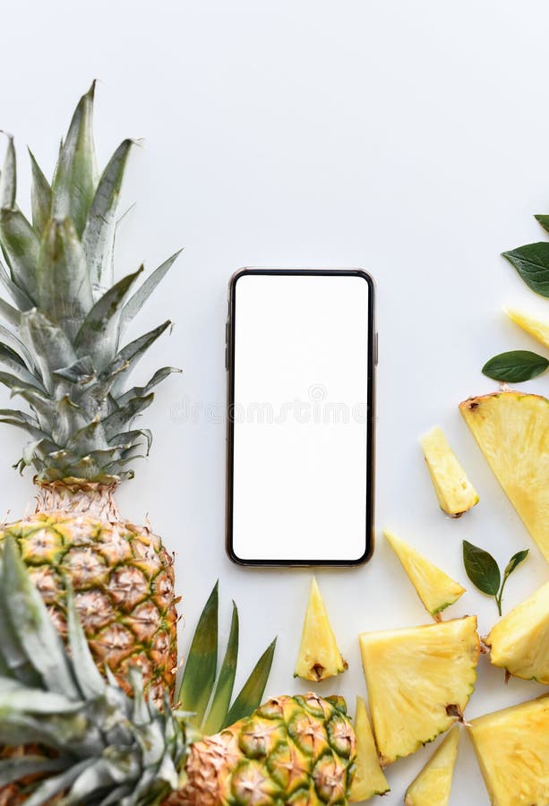 Smartphone Surrounded with Whole and Sliced Pineapple Over White. Top ...