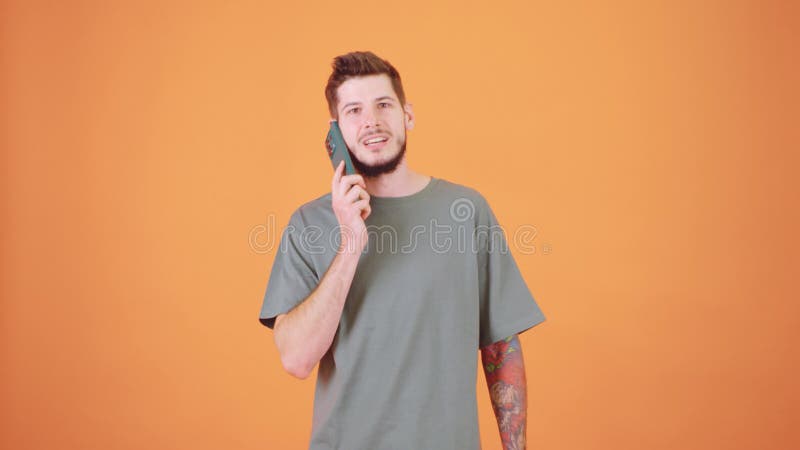 The Young Man Answers a Phone Call, Holding the Phone To His Ear with a ...