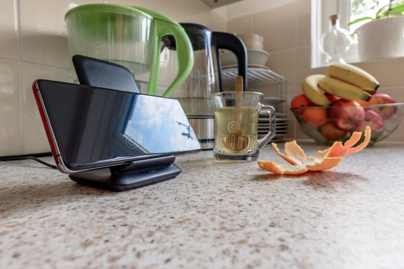 Smartphone Wireless Charging on Charging Stand on Kitchen Tabletop ...