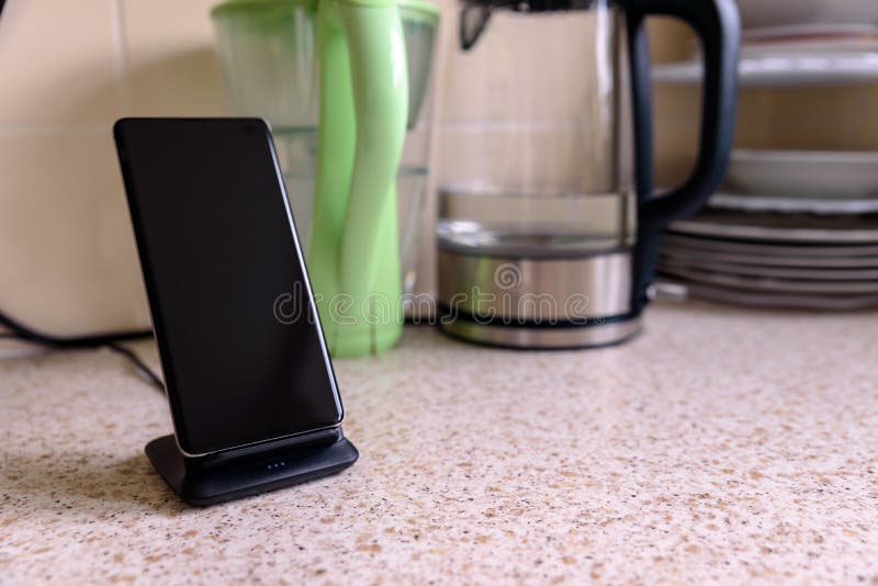 Smartphone Wireless Charging on Charging Stand on Kitchen Tabletop ...