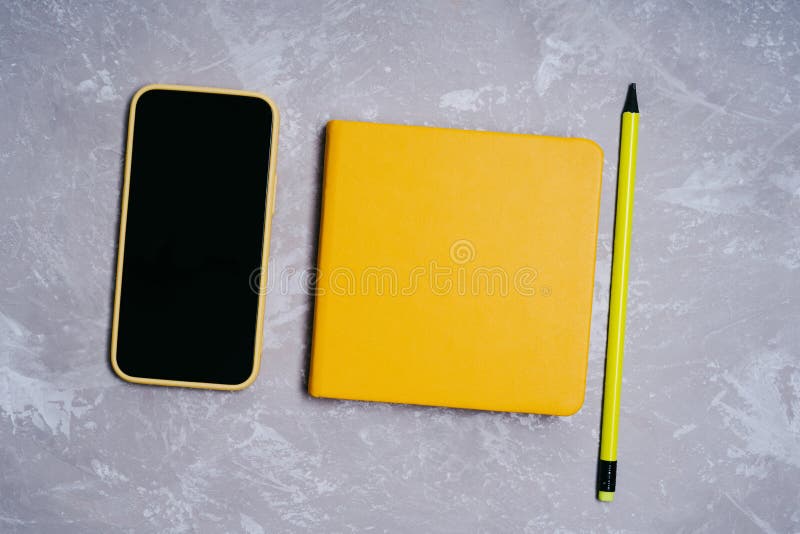 Smartphone in a Yellow Silicone Case, a Simple Pencil and Notepad or ...
