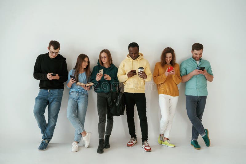 With Smartphones in Hands. Group of Young People are Standing Against ...