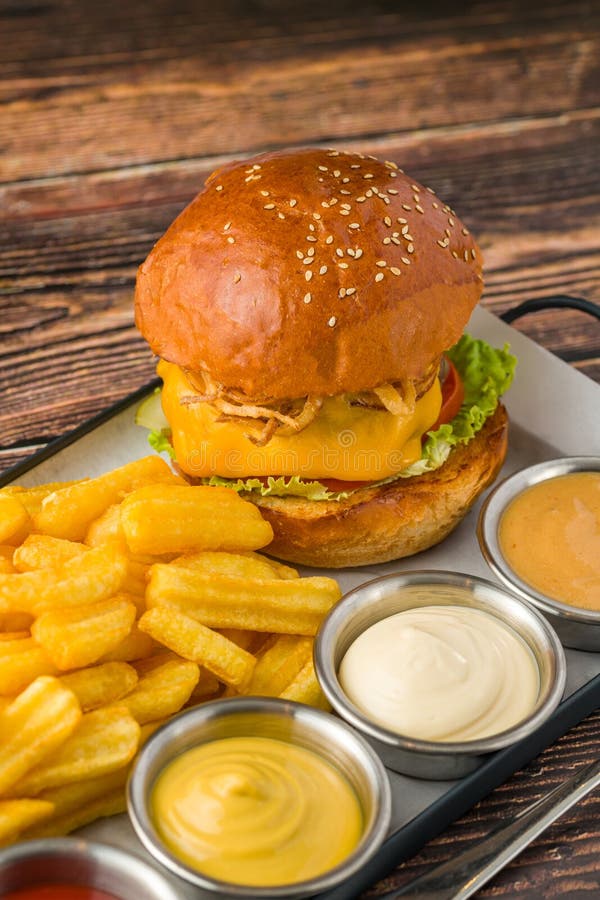 Smash Burger with Crispy Onions Served with Fries and Sauces Stock ...