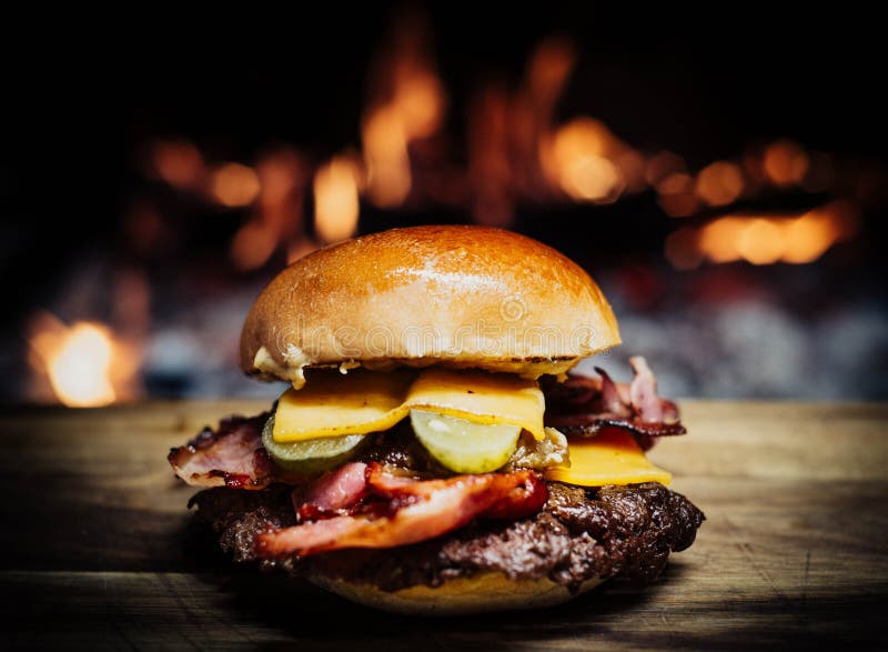Smashed Cheeseburger on a Wooden Table in Front of a Fireplace. Stock ...