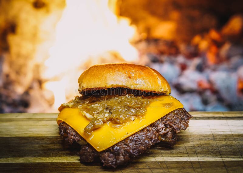 Smashed Cheeseburger on a Wooden Table in Front of a Fireplace. Stock ...