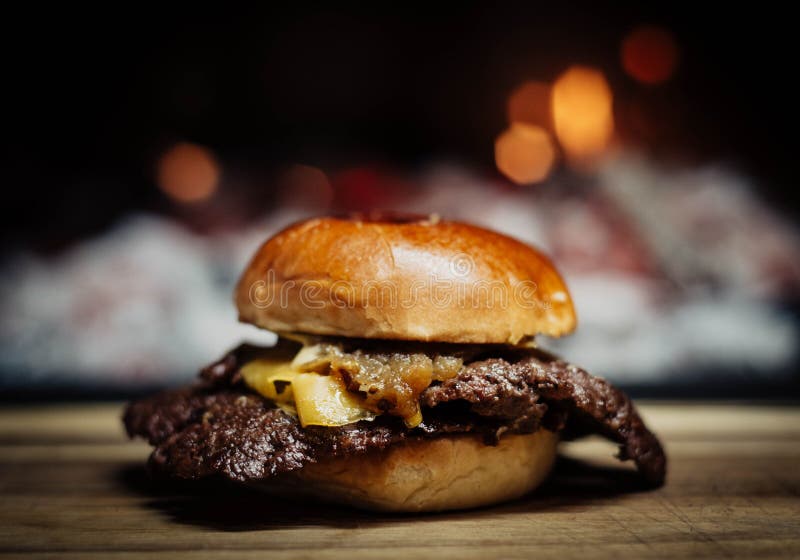 Smashed Cheeseburger on a Wooden Table in Front of a Fireplace. Stock ...