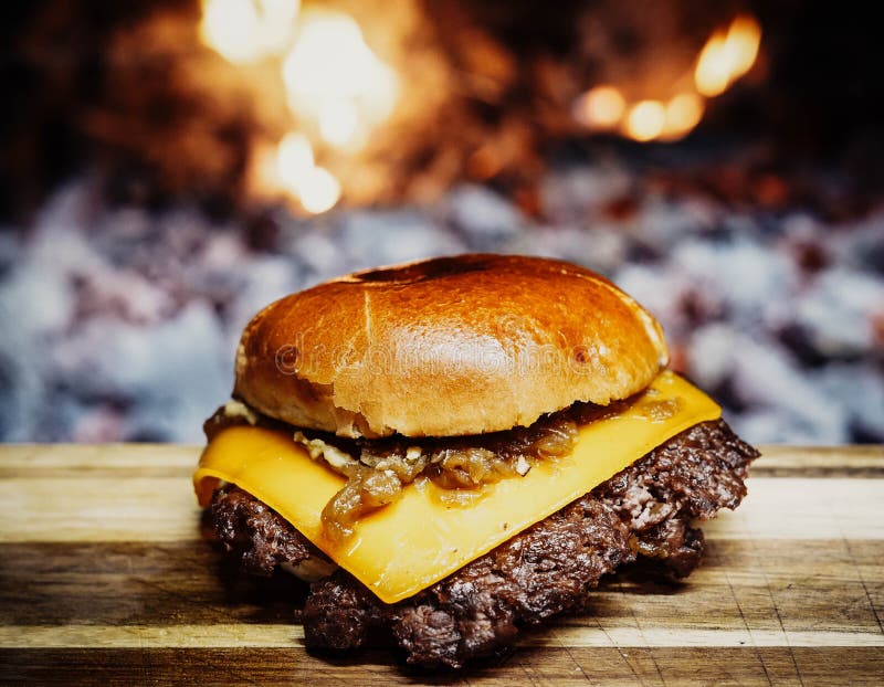 Smashed Cheeseburger on a Wooden Table in Front of a Fireplace. Stock ...