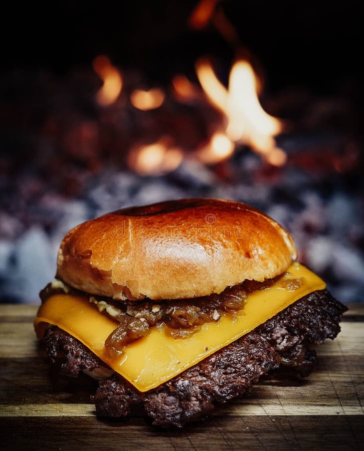 Smashed Cheeseburger on a Wooden Table in Front of a Fireplace. Stock ...