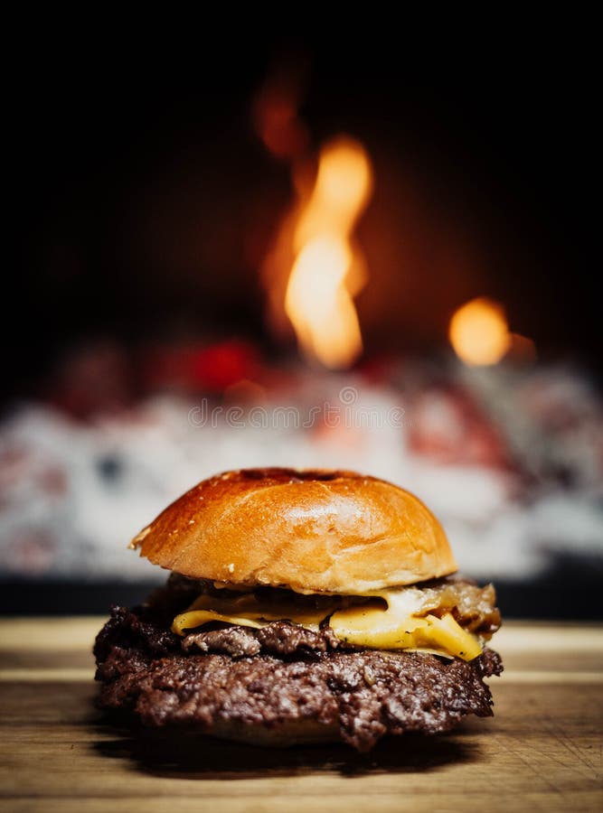 Smashed Cheeseburger on a Wooden Table in Front of a Fireplace. Stock ...