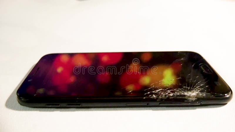 Smashed Glass of Mobile Phone on Table Rotating in Light with Half the ...