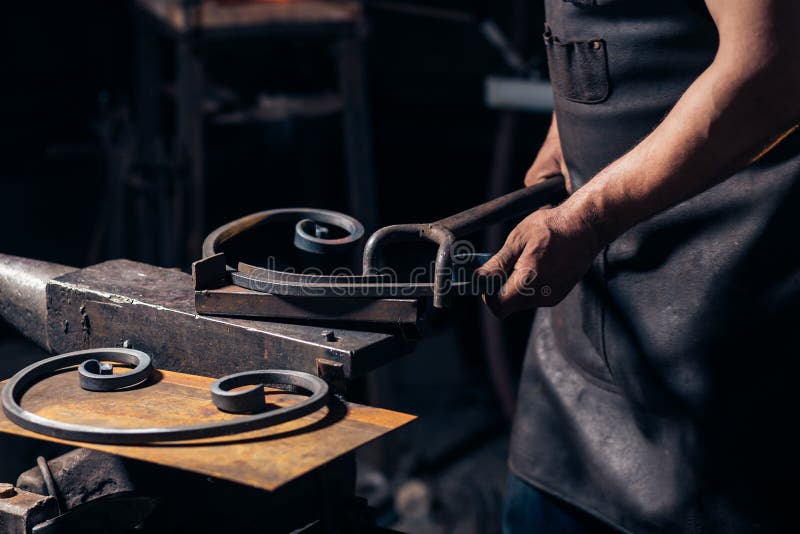 Smeed De Smid Verwerkt Het Verwarmde Metaal Met Een Voorhamer Op Het ...