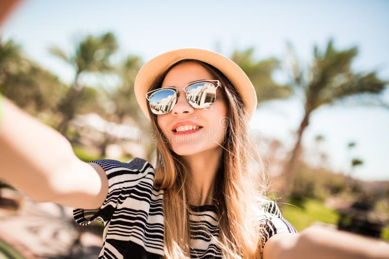 Smile Woman In Hat And Sunglasses Taking Selfie With Mobile Phone From Hands On Summer Resort