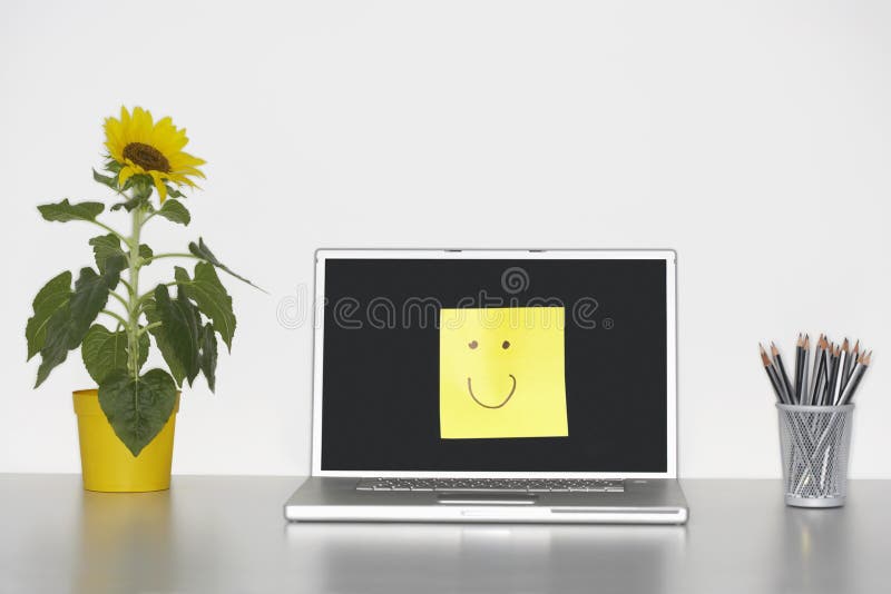 Smiley Face on Laptop Screen with Flowers and Pencils Stock Image ...
