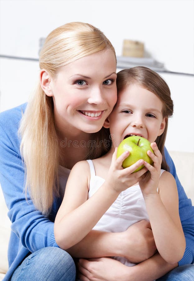 Smiley Mum with Her Eating Apple Daughter Stock Photo - Image of happy ...