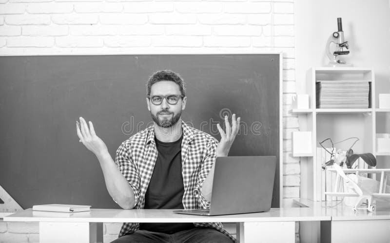 Smiling Adult Man Tutor Sitting in Classroom at Blackboard, Education ...