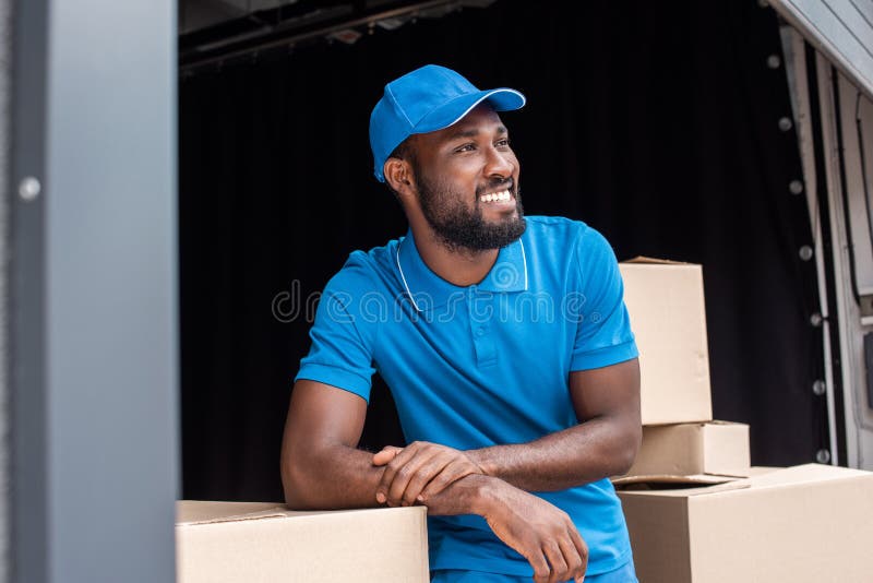 Smiling African American Courier Leaning on Boxes Stock Image - Image ...