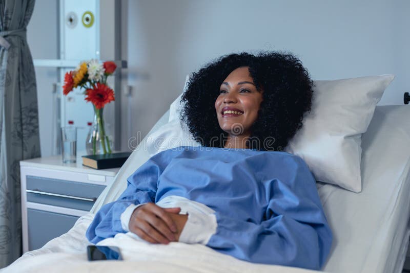 Smiling African American Female Patient Lying In A Hospital Bed Stock