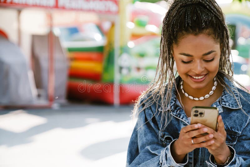 Smiling African American Woman Using Mobile Phone While Standing In