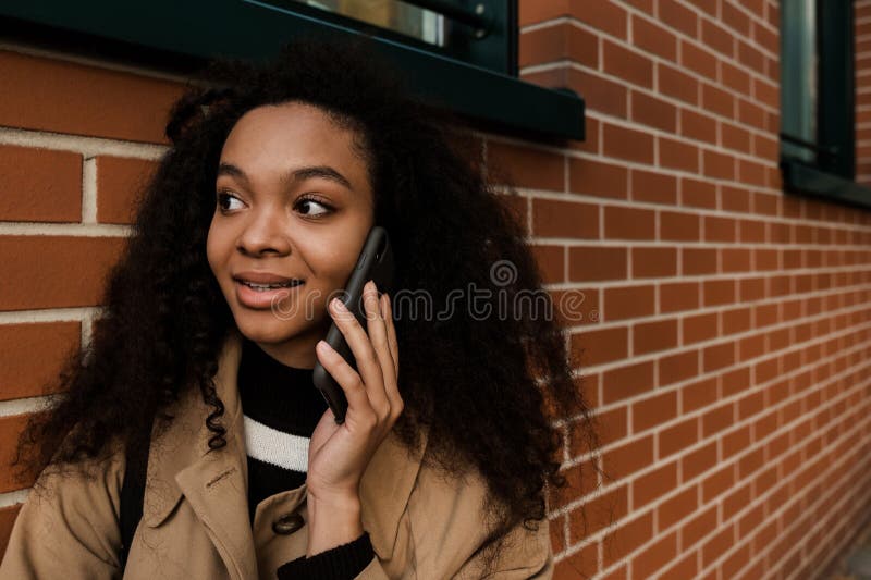 Smiling African Girl Talking On Mobile Phone And Looking Away While