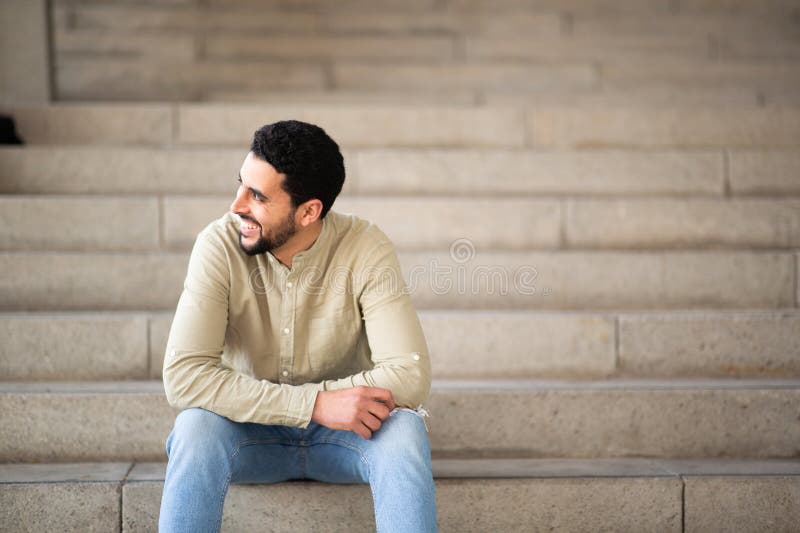Smiling Arabic Man Sitting on Steps Looking Away Stock Photo - Image of ...