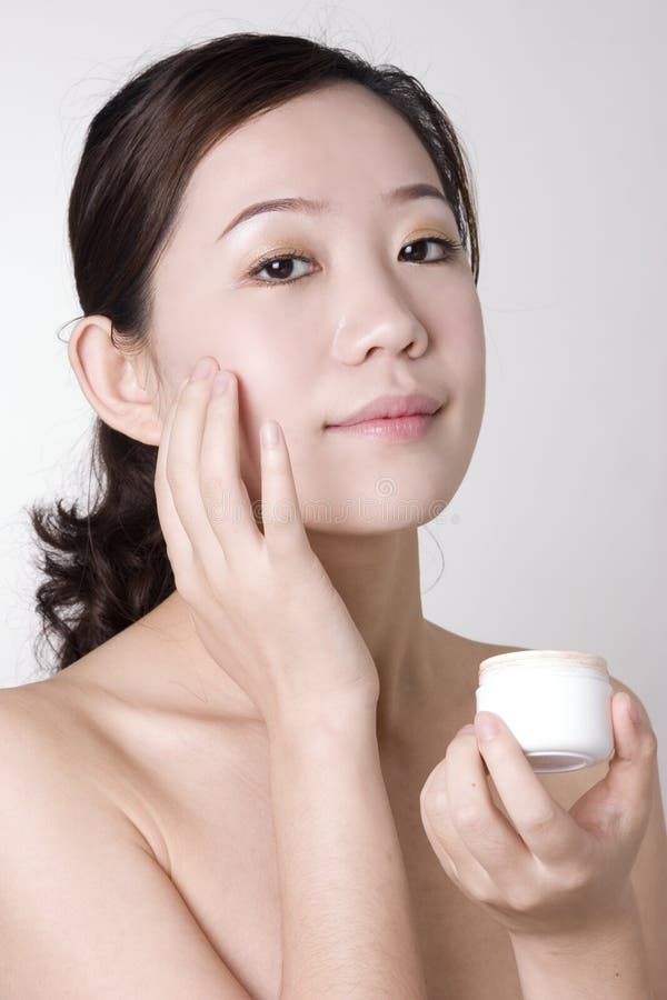 Smiling Asian Girl with a Lotion on Her Hand Stock Photo - Image of ...