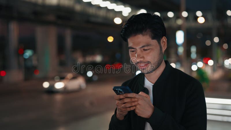 Smiling Asian Man Staring at Cell Phone Screen by Highway Stock Footage ...
