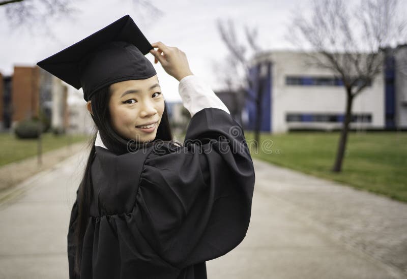 Smiling Asian Student Celebrating Graduation Adjusting Her Mortarboard ...