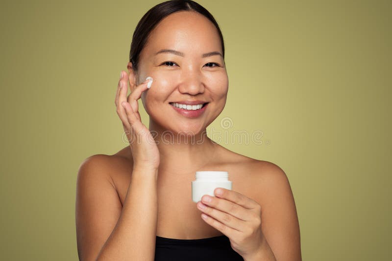 Smiling Asian Woman Applying Facial Cream Stock Image Image Of Pamper