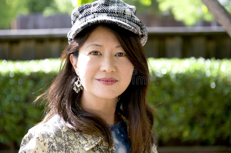 Smiling Asian Woman with Herringbone Cap Stock Photo - Image of ...
