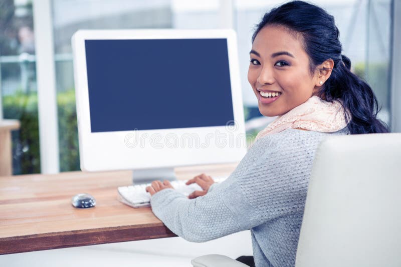 Smiling Asian Woman Using Computer Looking Back at the Camera Stock ...
