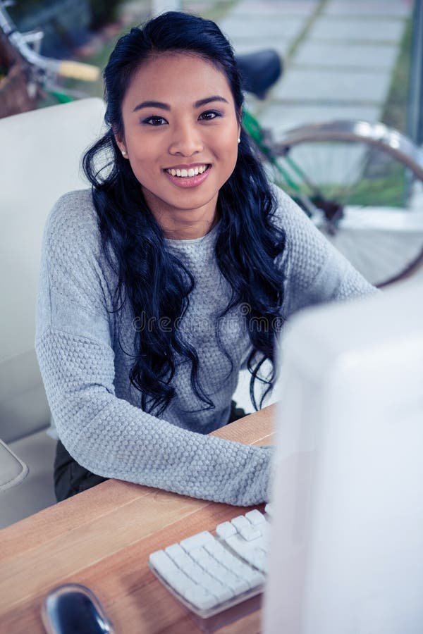 Smiling Asian Woman Using Computer and Looking at the Camera Stock ...